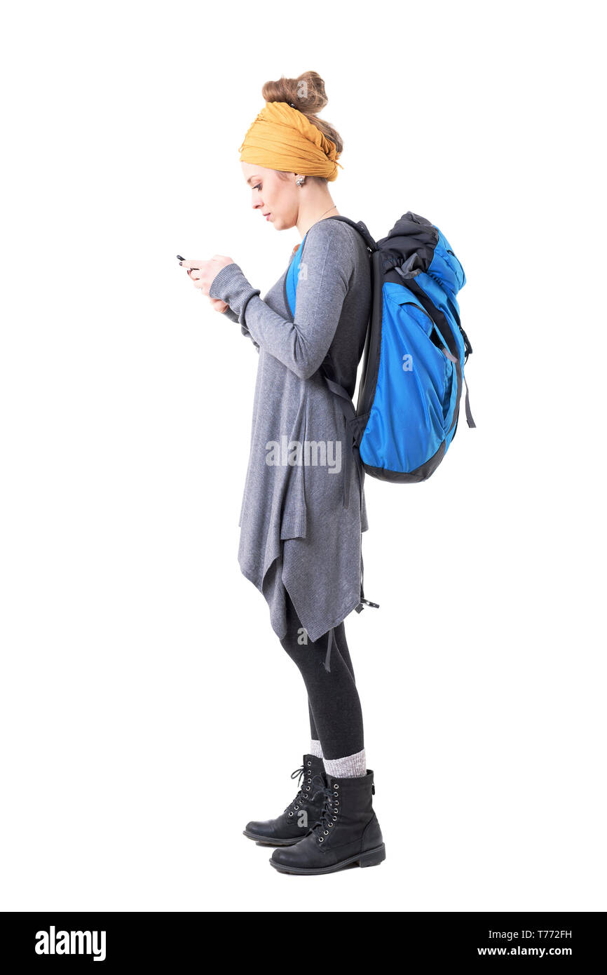 Side view of young backpacker woman using smart phone map navigation ...