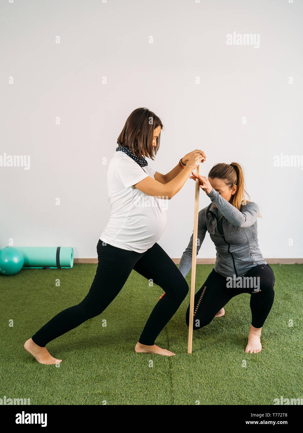 Pregnant woman doing fitness ball and pilates exercise with coach ...