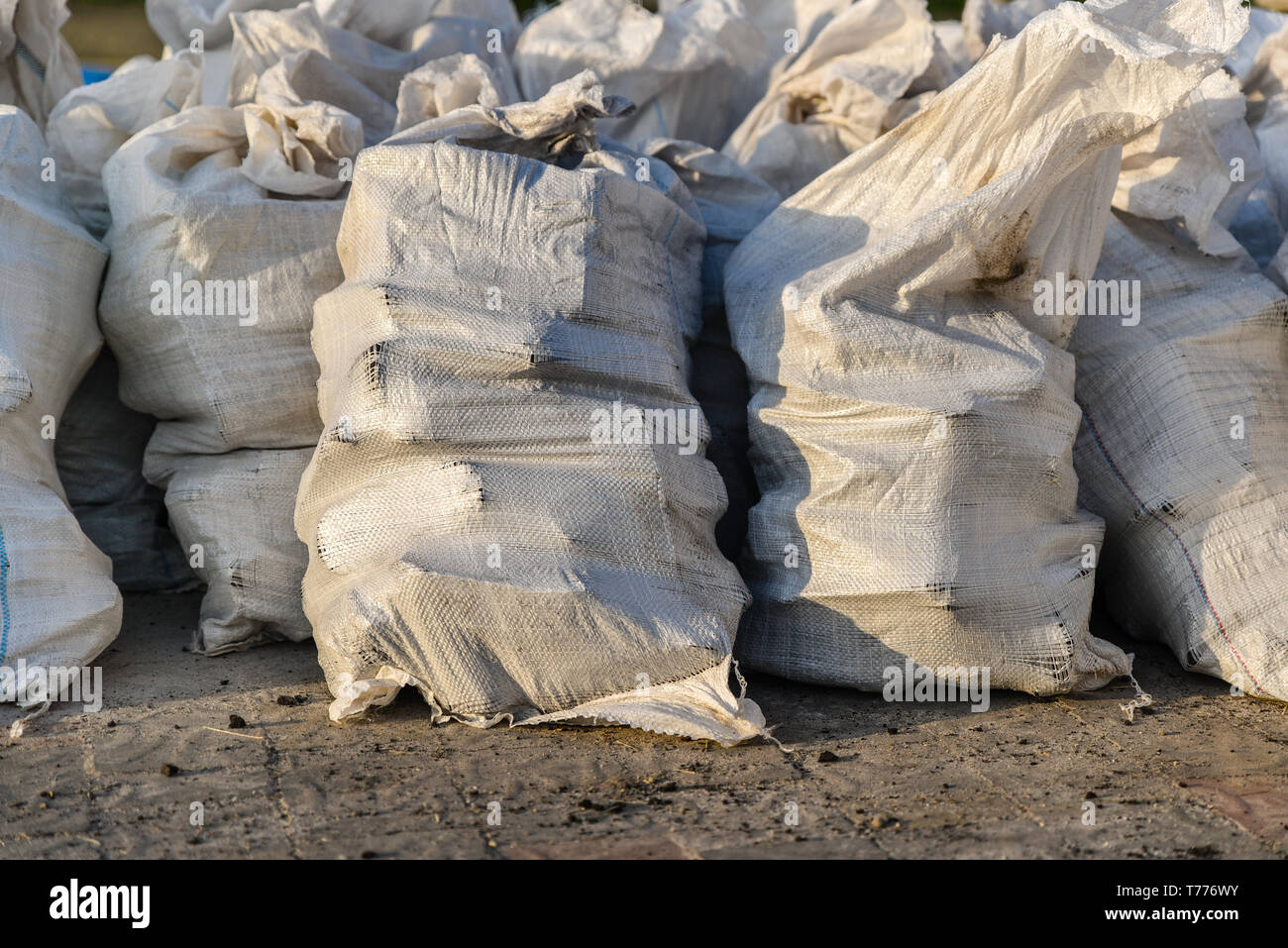 Group of filled plastic woven sacks, packing of goods for ...