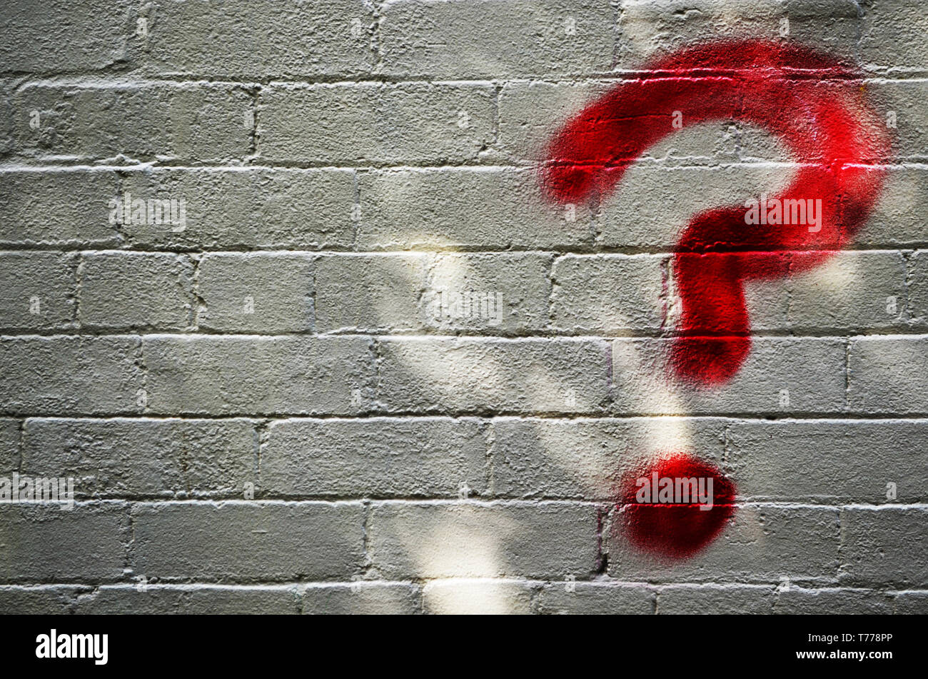 Question mark on white brick wall Stock Photo - Alamy