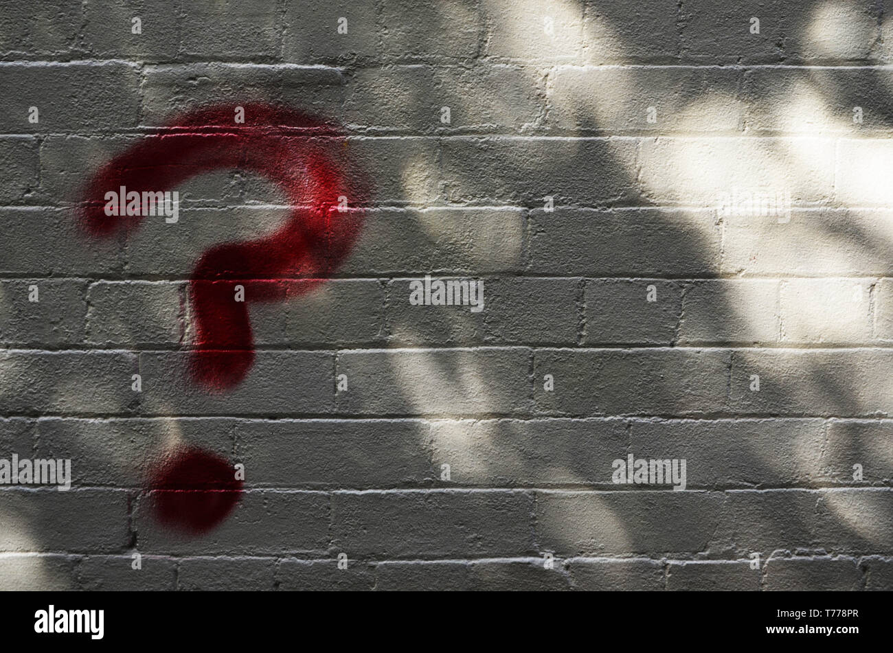 Question mark on white brick wall Stock Photo - Alamy