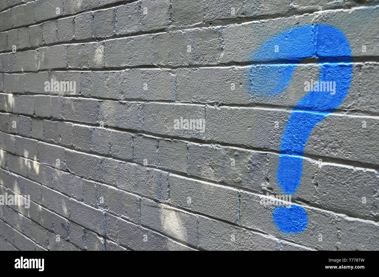 Question mark on white brick wall Stock Photo - Alamy