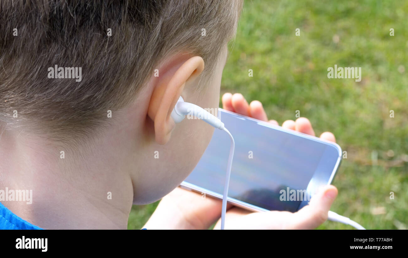 sad teen boy with smart phone listening or talking while sitting in ...