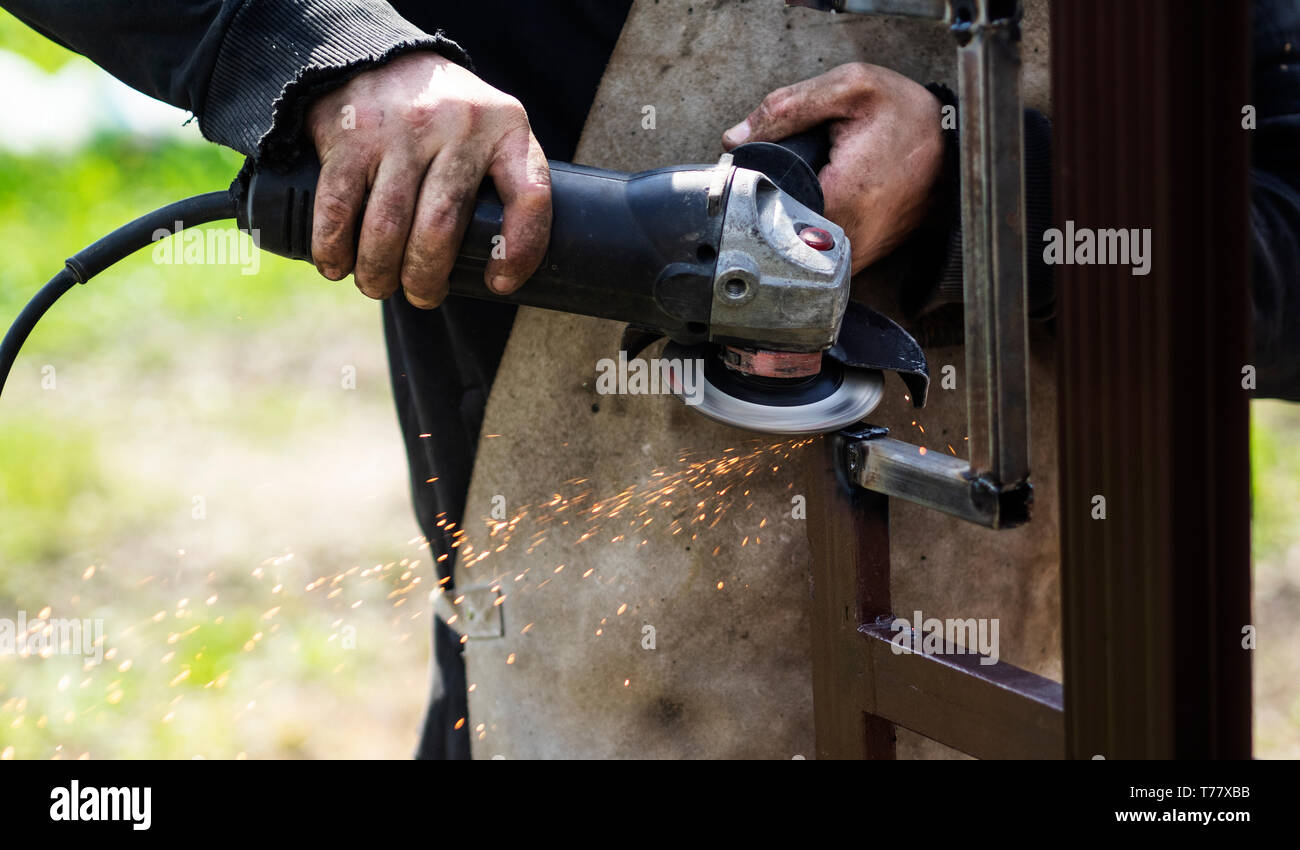 Hands of a metal worker using a grinder Stock Photo - Alamy