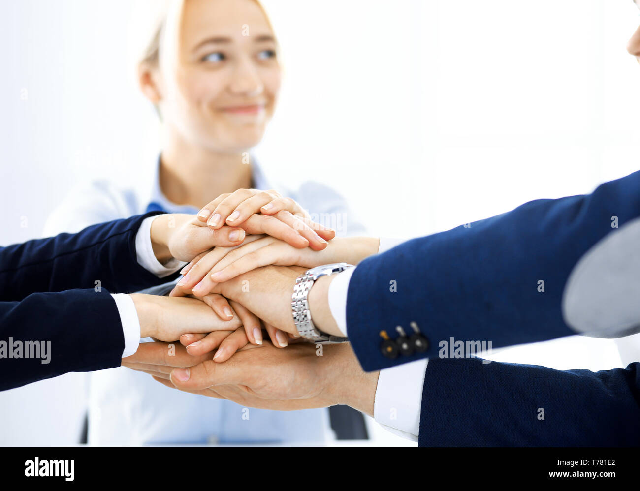 Business team showing unity with their hands together. Group of people joining hands and ...