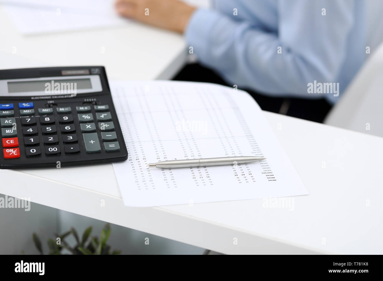 Calculator and binders with papers are waiting to be processed by ...