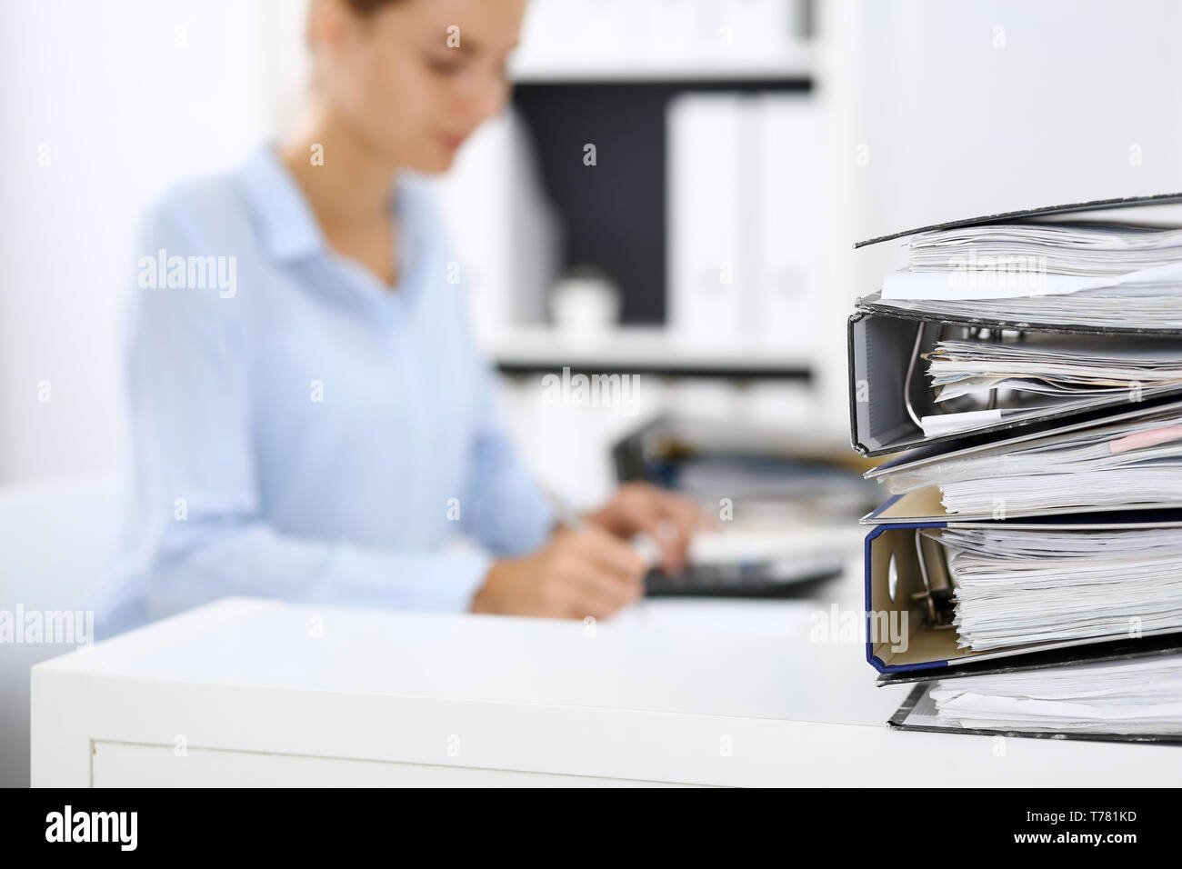 Calculator and binders with papers are waiting to be processed by ...