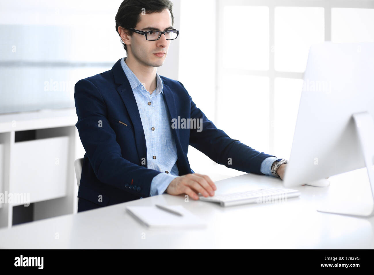 Businessman working with computer in modern office. Headshot of male ...