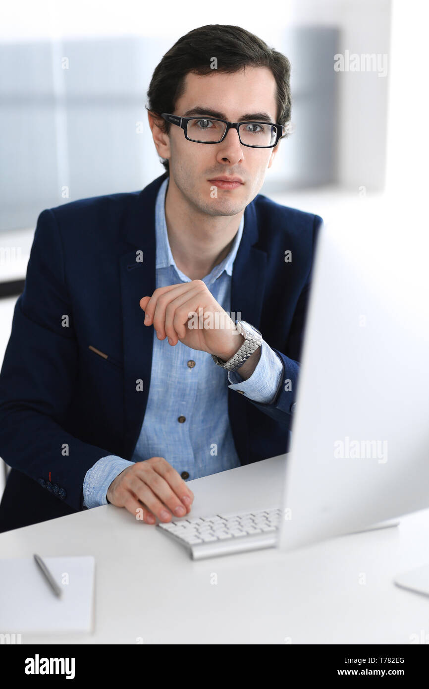 Businessman working with computer in modern office. Headshot of male ...