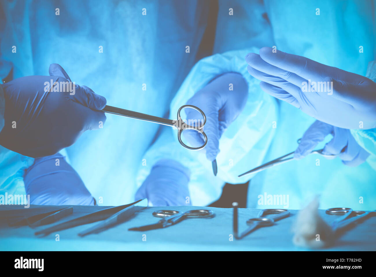 Surgeons hands holding surgical scissors and passing surgical equipment ...