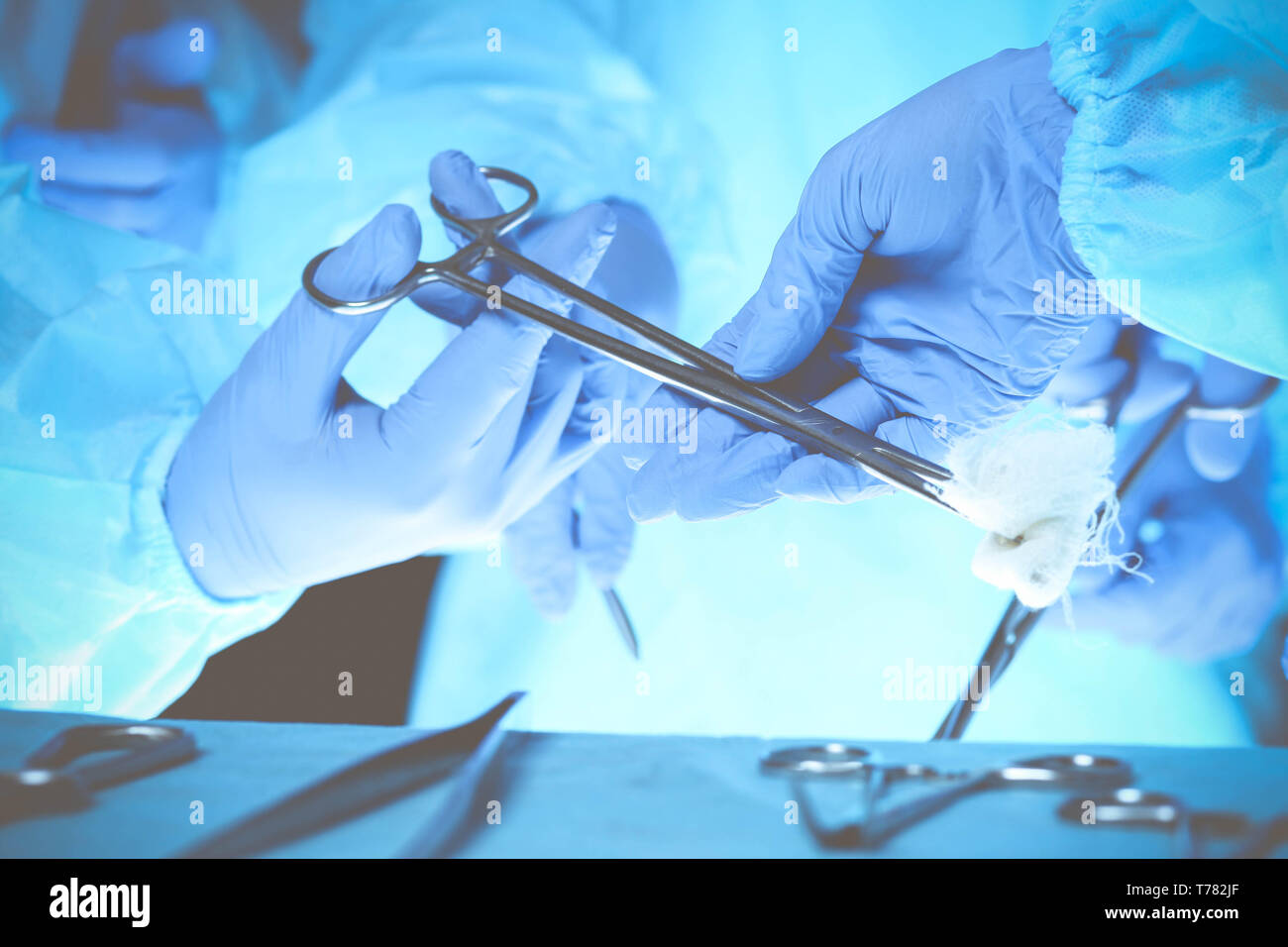 Surgeons hands holding surgical scissors and passing surgical equipment ...