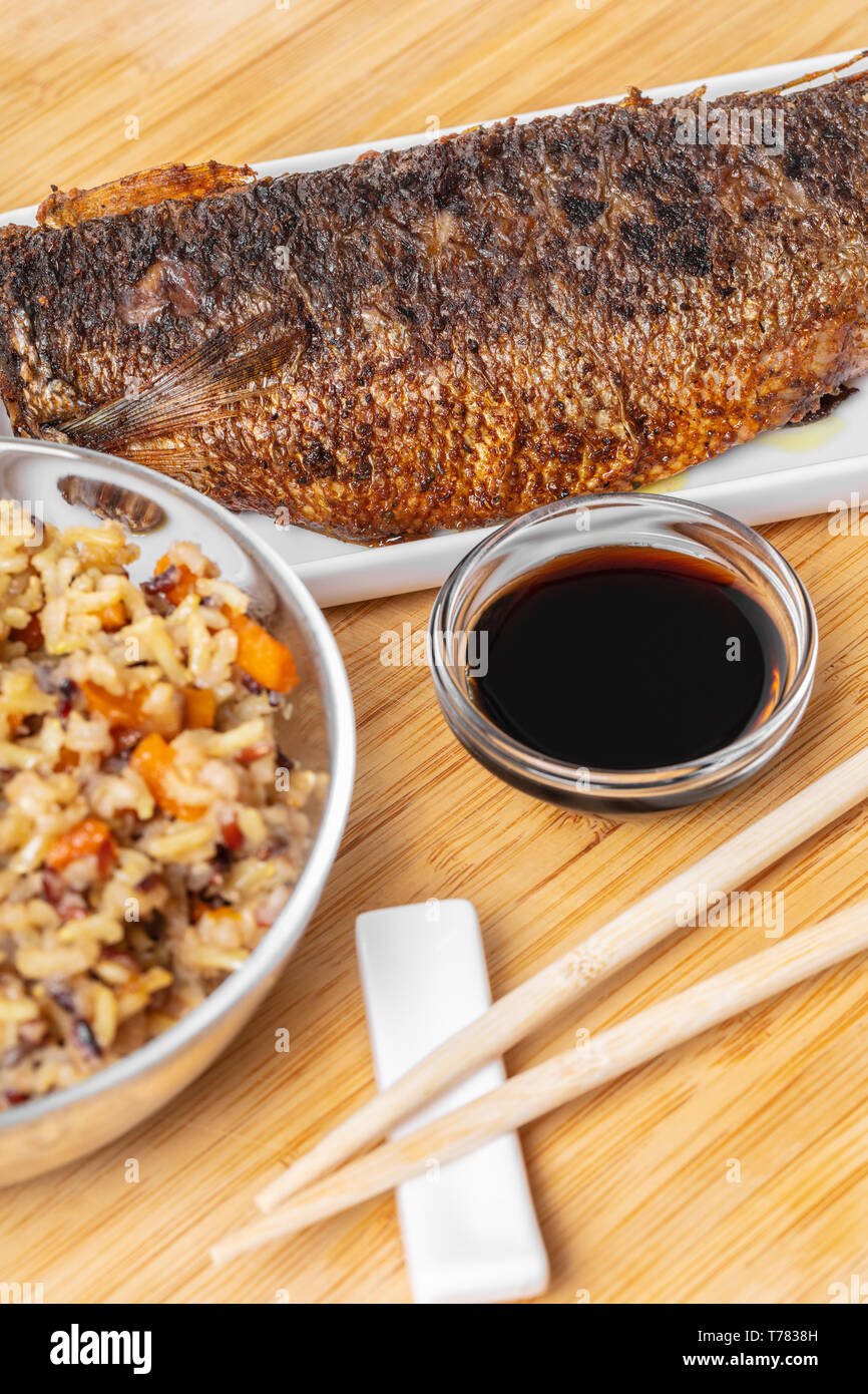 cooked fish with rice on wooden background Stock Photo - Alamy