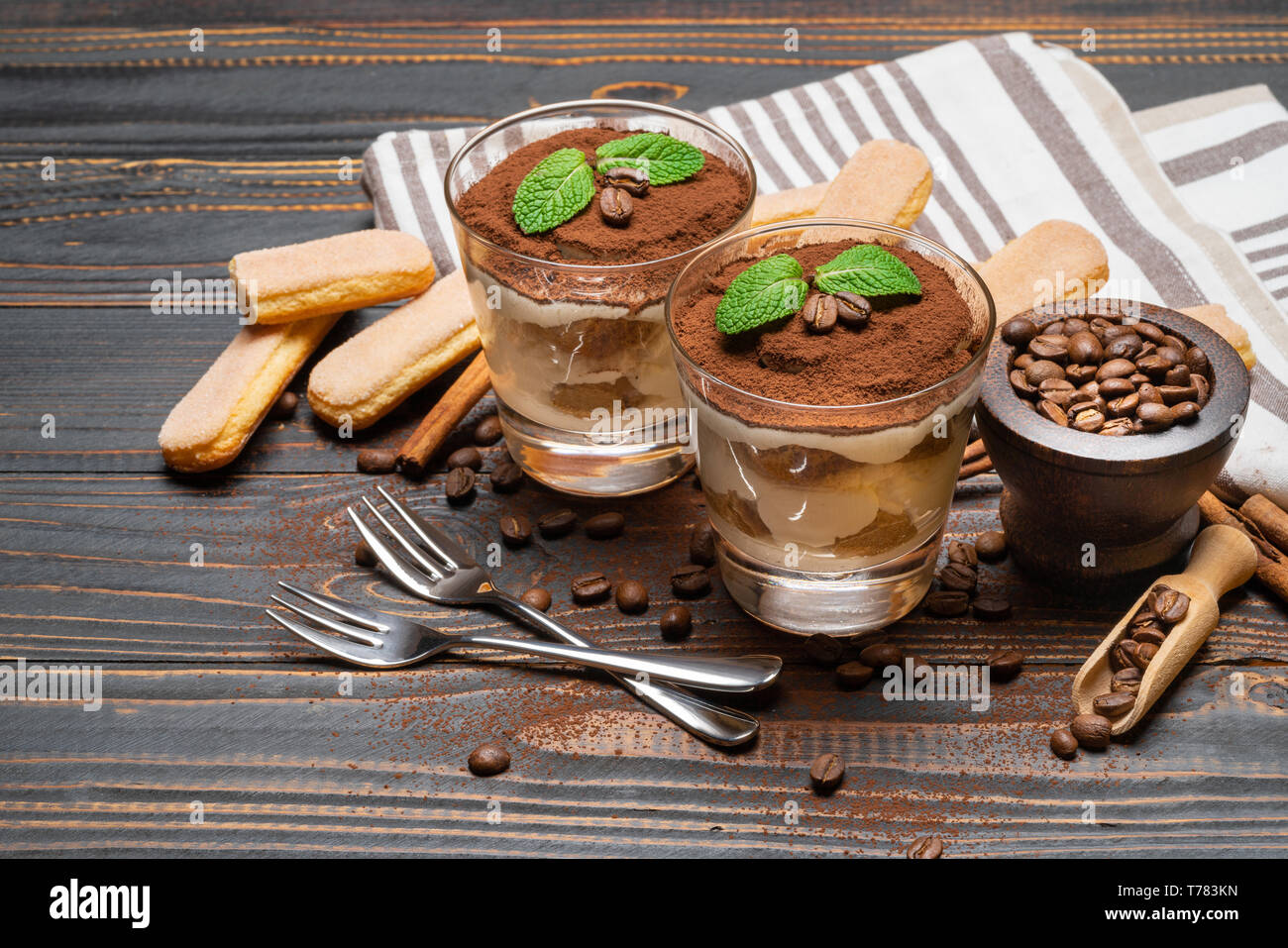 two portions Classic tiramisu dessert in a glass on wooden background ...