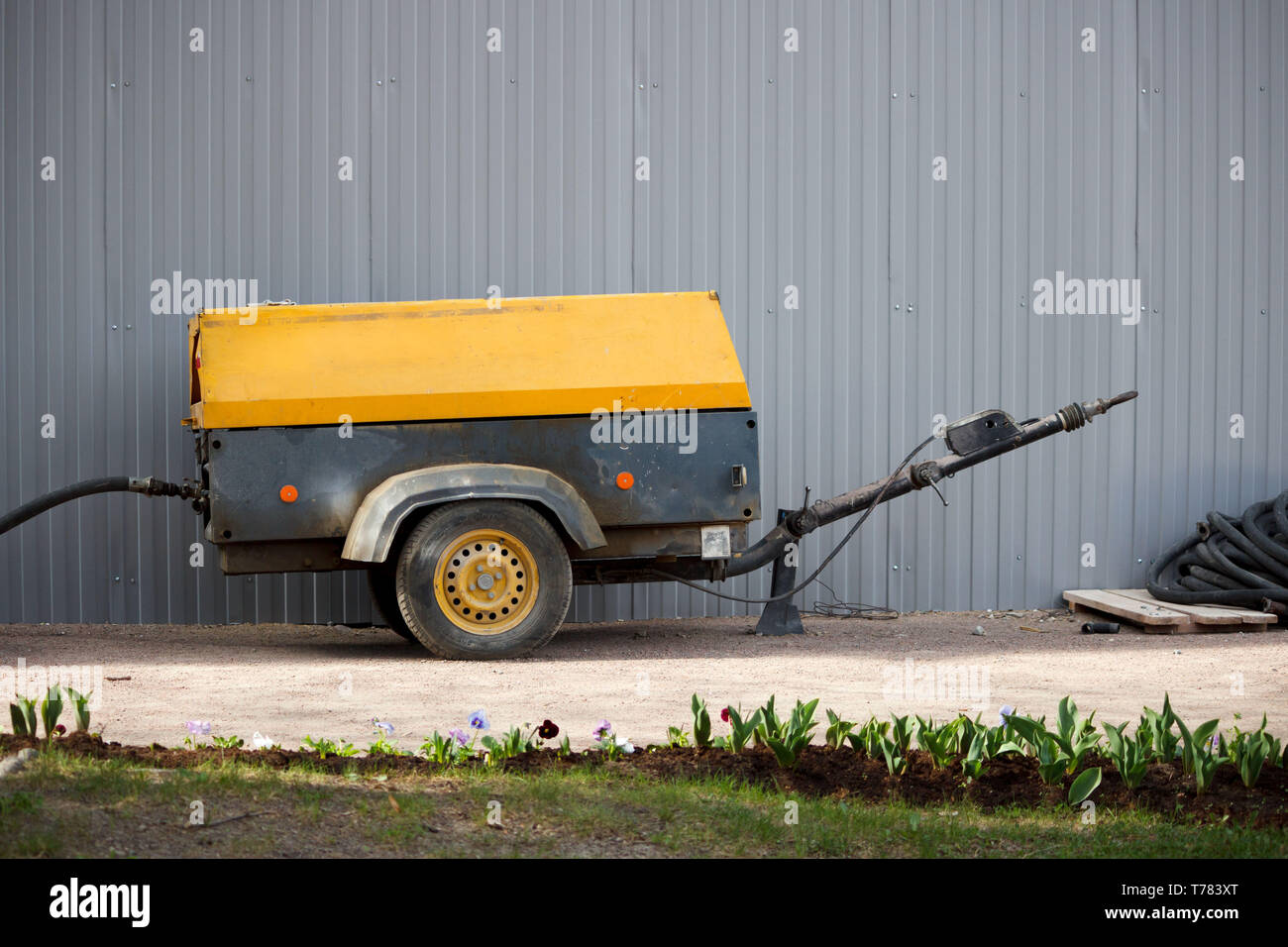 a large working air compressor stands near the fence next to the ...