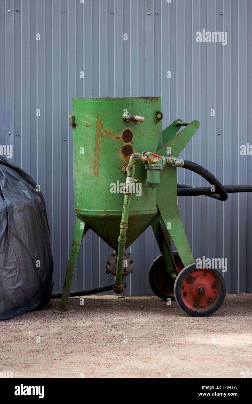 worker green old air sand blower Sandblast stands near the fence next ...