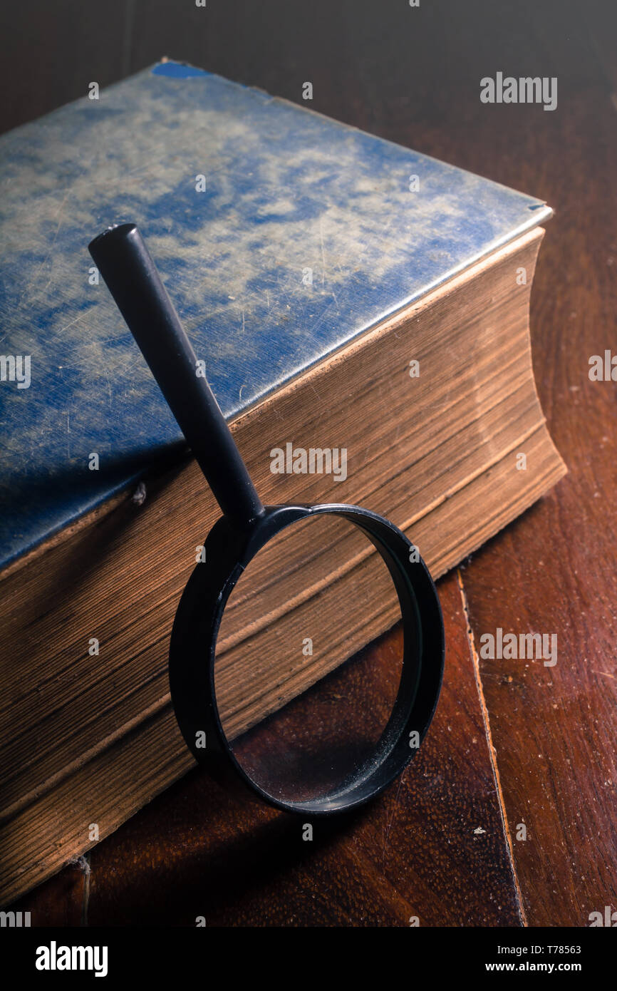 Still life Antique book with magnifier Stock Photo - Alamy