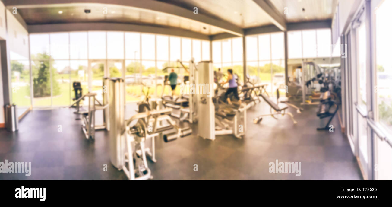 Panoramic blurry background open fitness center with people workout at ...