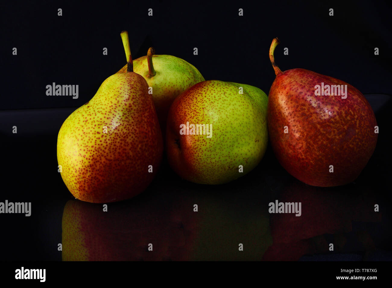Red and green Pears on black dish Stock Photo - Alamy