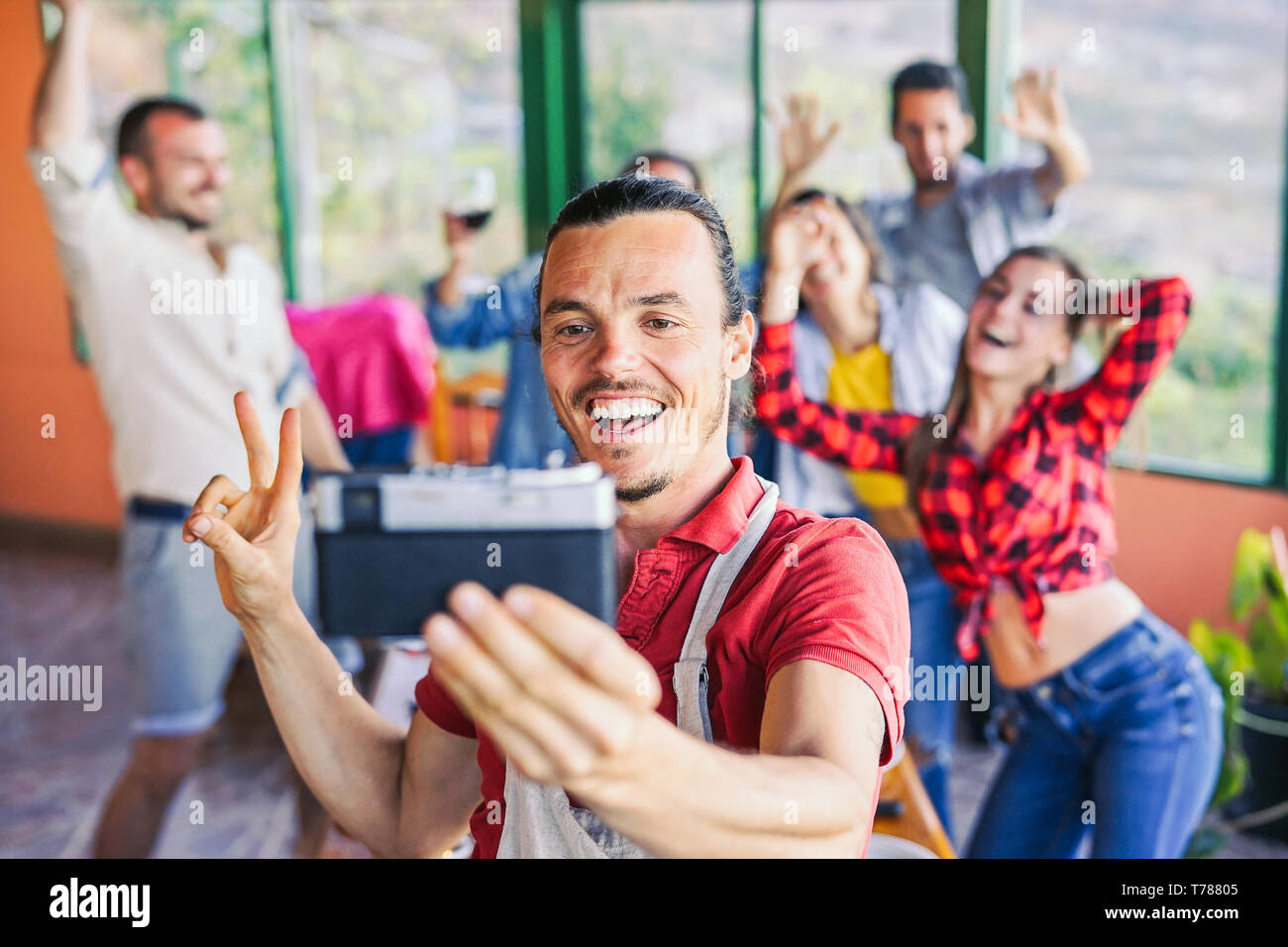 Group of friends taking photo with old vintage instant camera at dinner ...