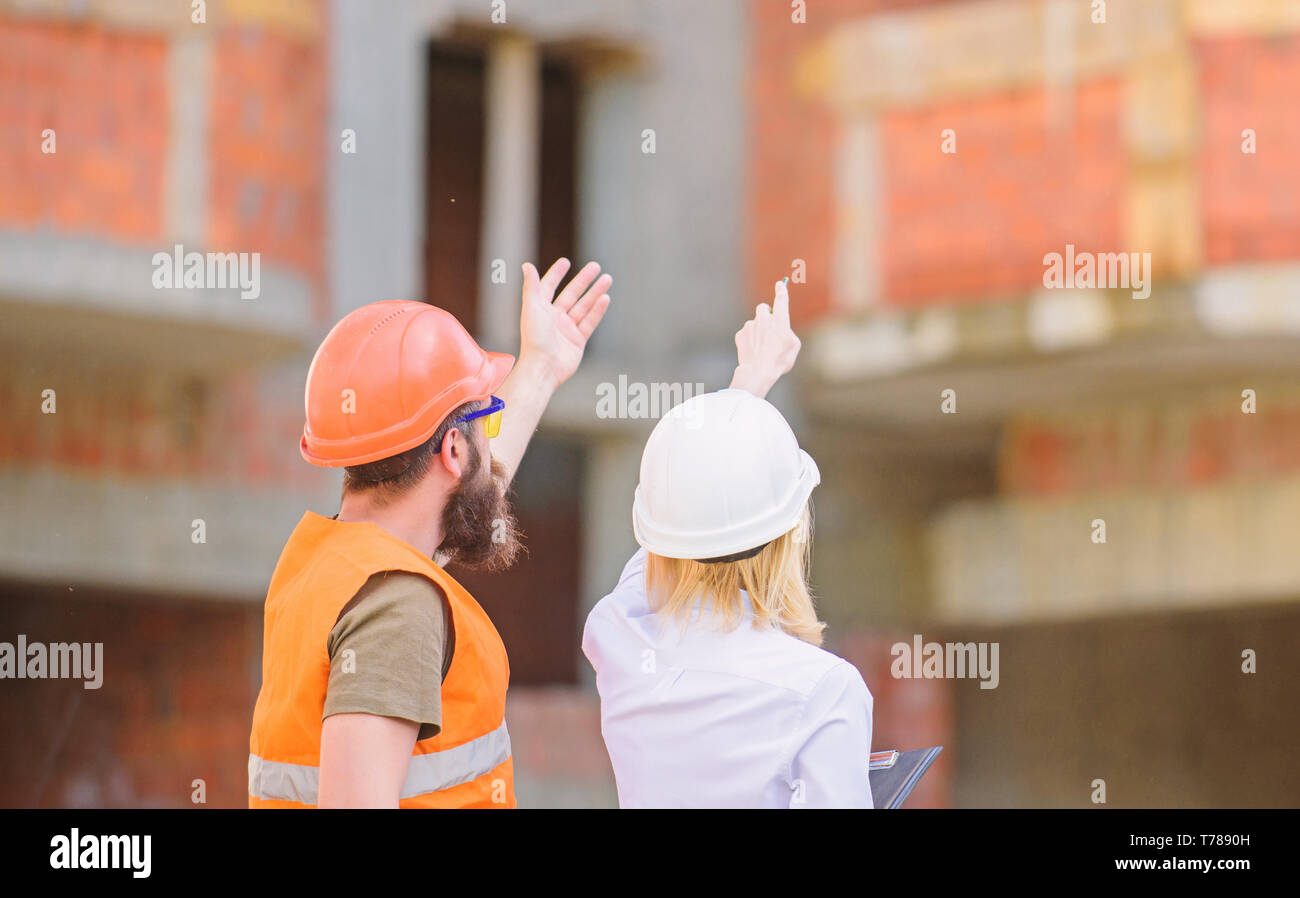 Woman engineer and builder communicate construction site. Relationships ...