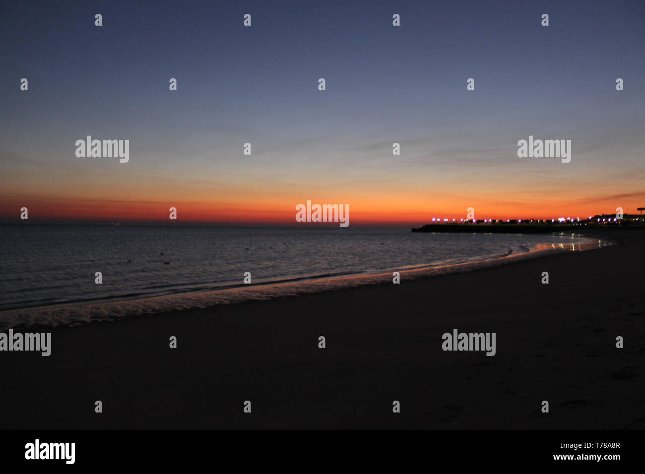 A man standing at the beach watching the sunrise hi-res stock ...
