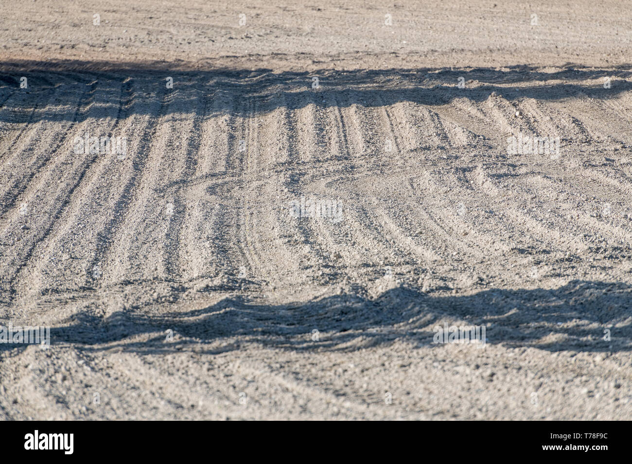 Dried earth in a tilled / ploughed field, with furrows / tyre marks ...