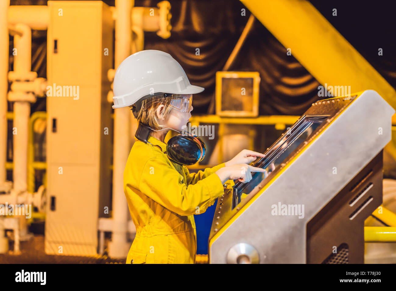 Boy operator recording operation of oil and gas process at oil and rig ...