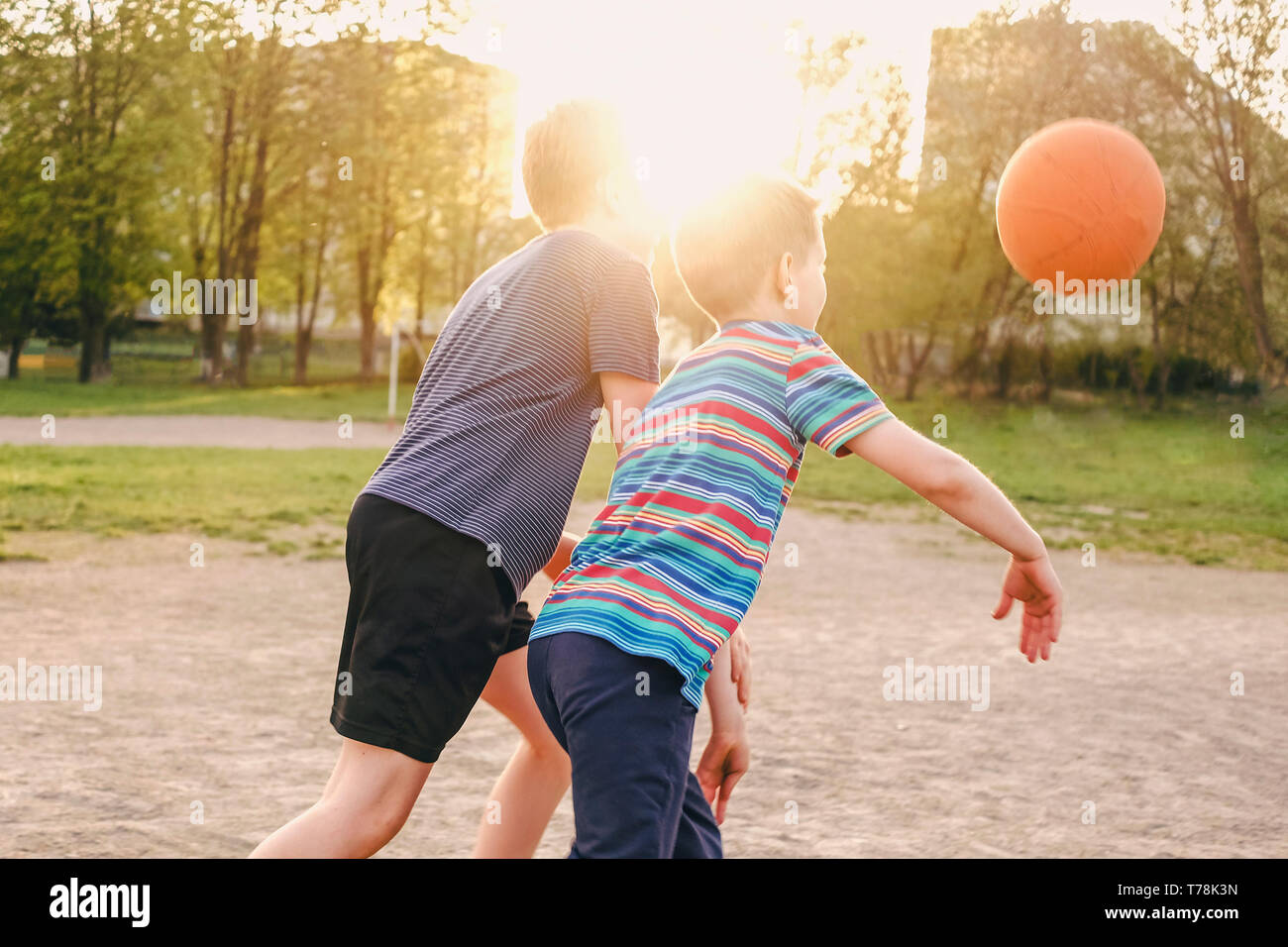 Two young boys enjoying a game of basketball challenging each other for ...
