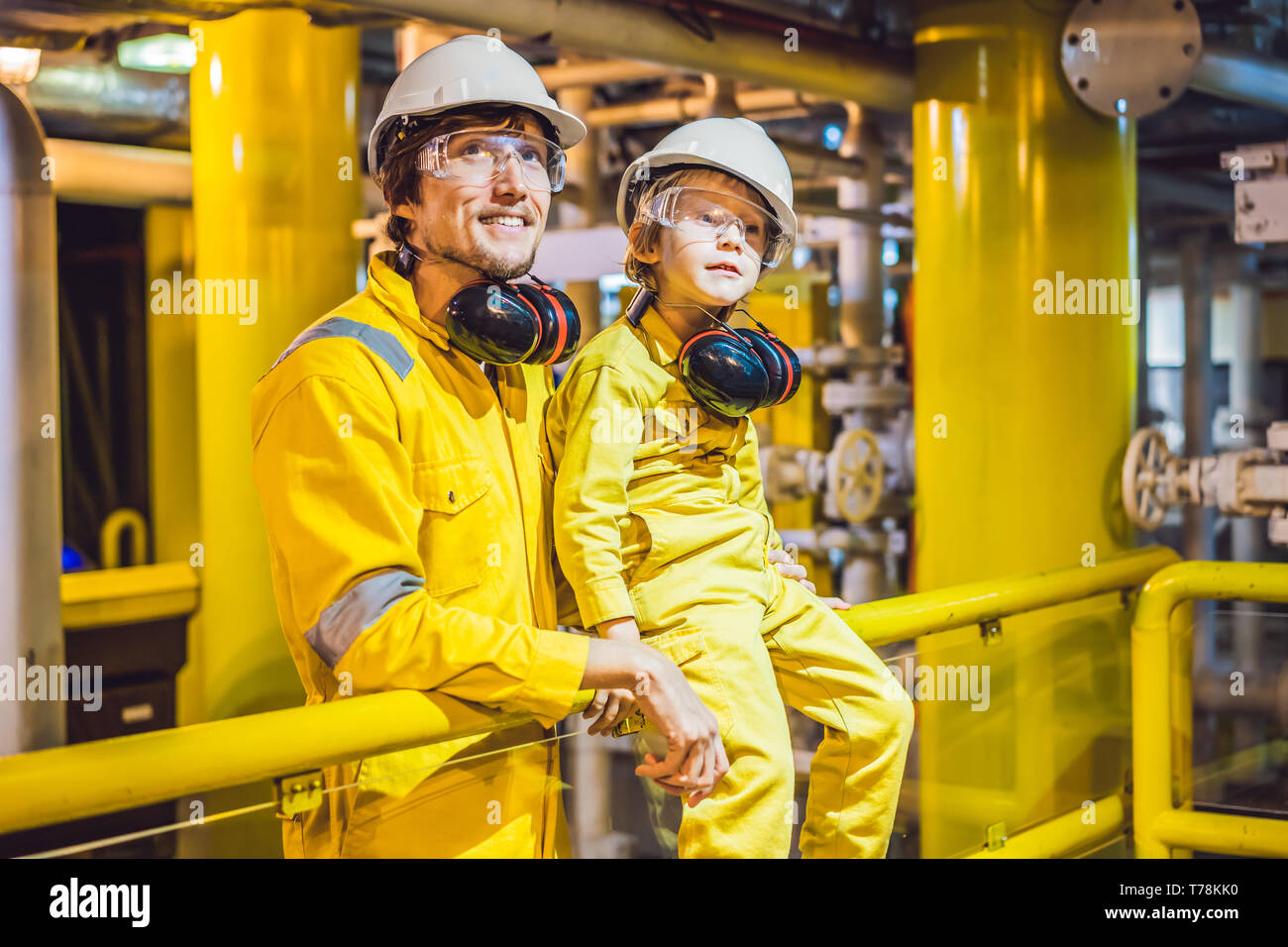 Young man and a little boy are both in a yellow work uniform, glasses ...