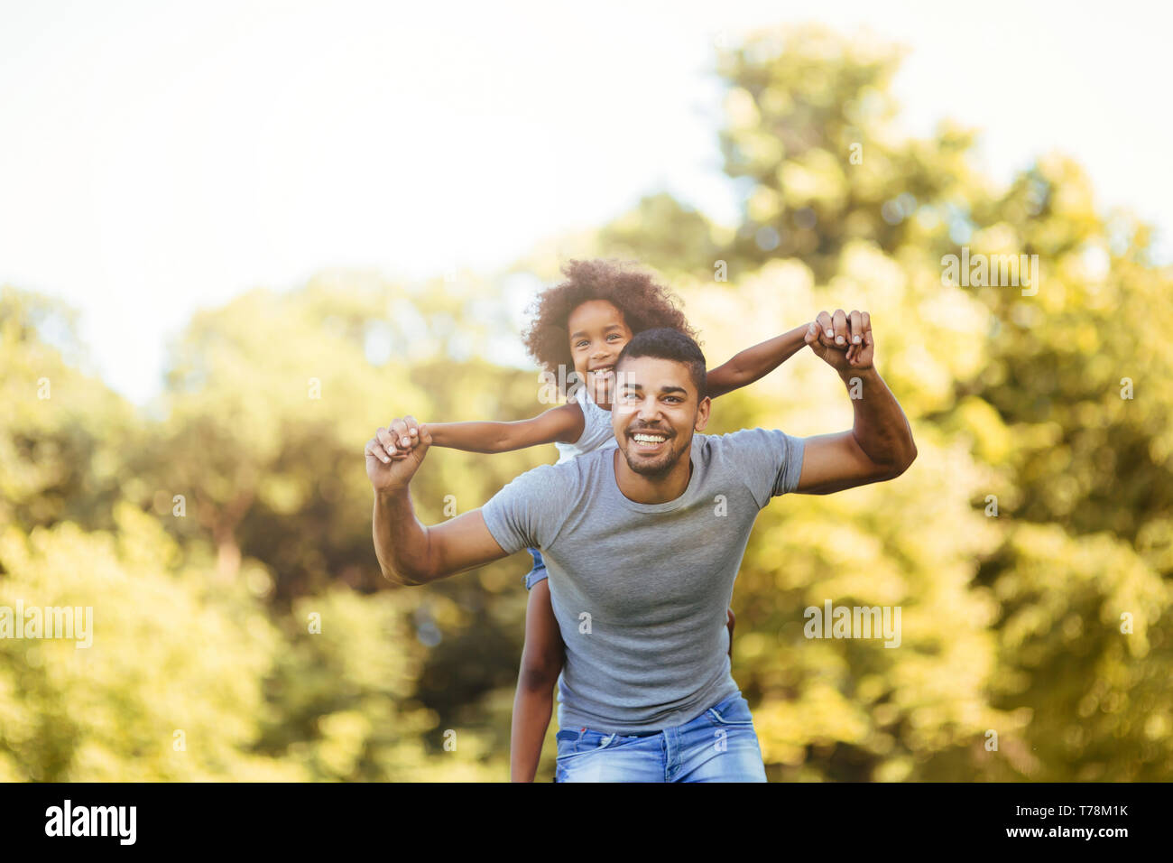 Portrait of young father carrying his daughter on his back Stock Photo ...