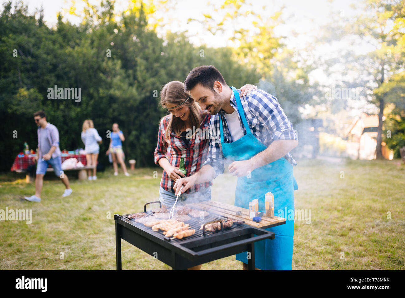 Happy students having barbecue on summer day Stock Photo - Alamy