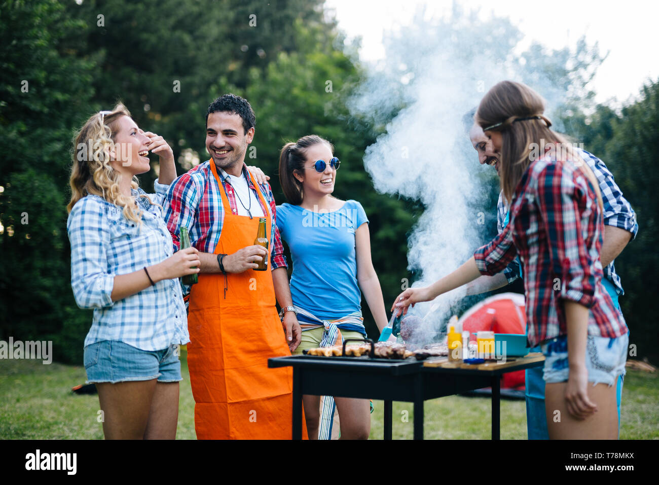 Happy students having barbecue on summer day Stock Photo - Alamy
