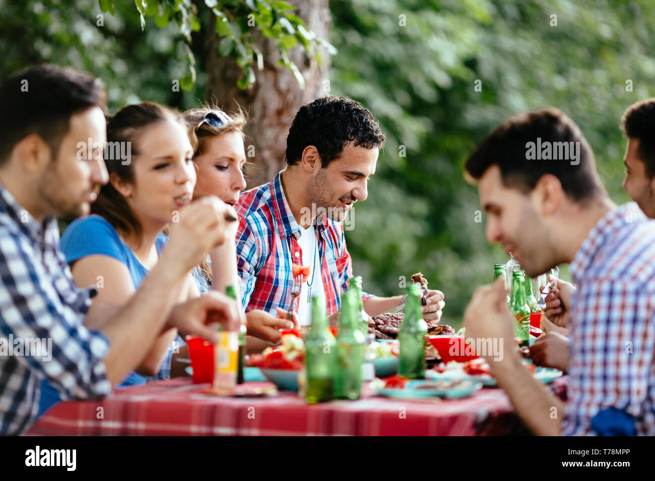 Group of happy people eating food outdoors Stock Photo - Alamy