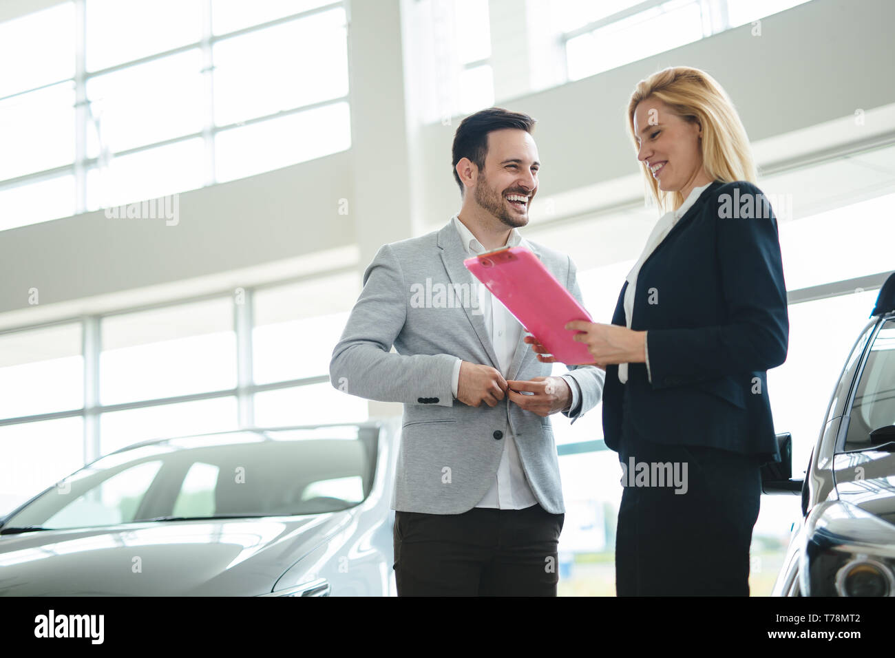 Dealer showing a new car model to the potential customer Stock Photo ...