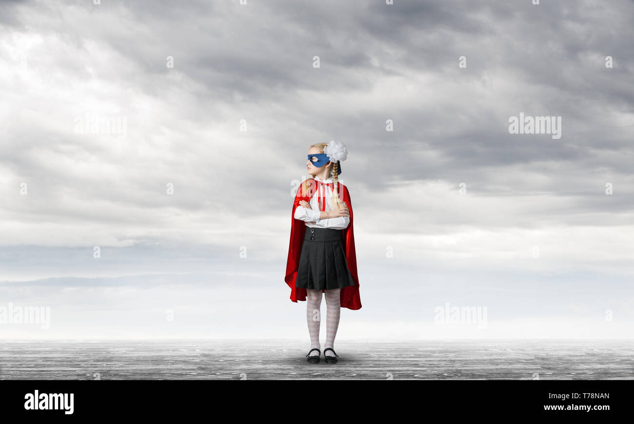 Girl power concept with cute kid guardian against cloudscape background ...