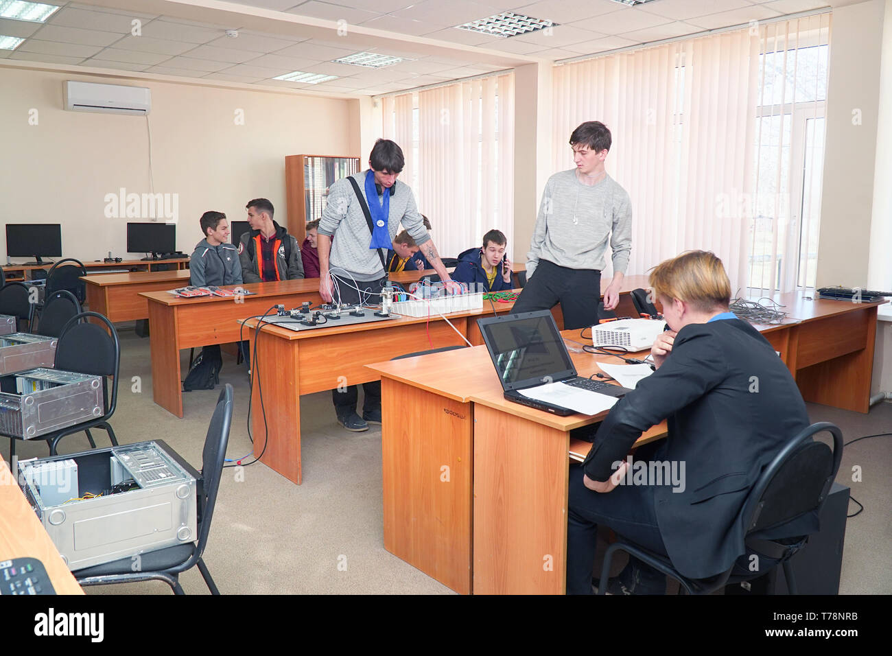 Students connect wires control panel with small test bench for ...