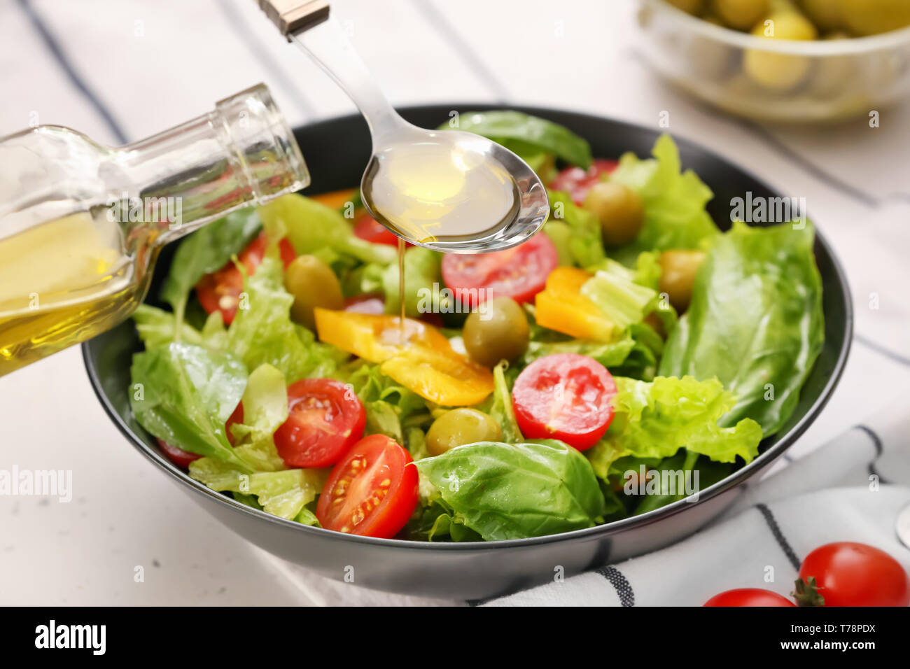 Dressing of fresh vegetable salad with olive oil Stock Photo - Alamy