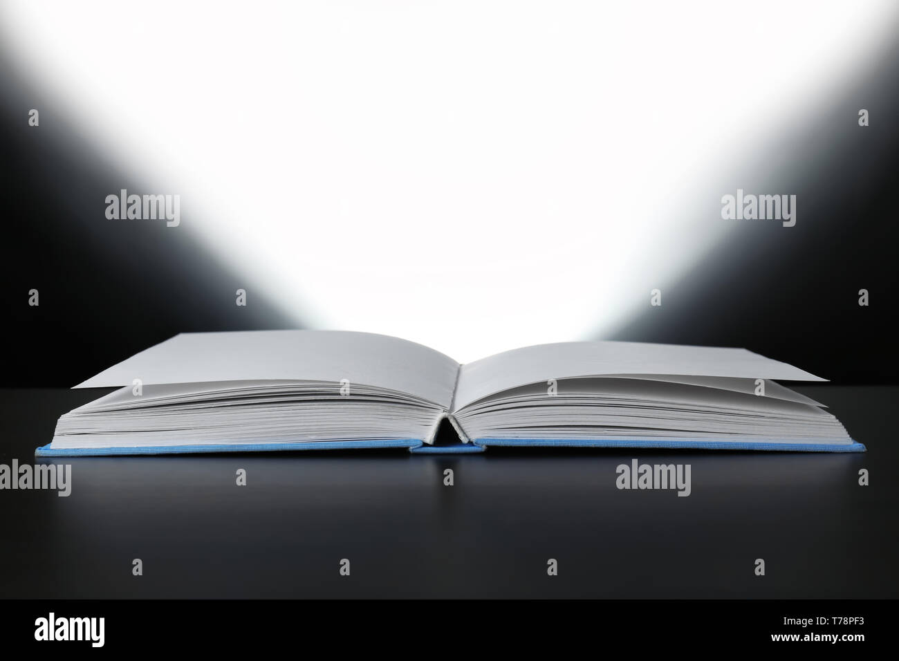 Open book with glowing on dark background Stock Photo - Alamy