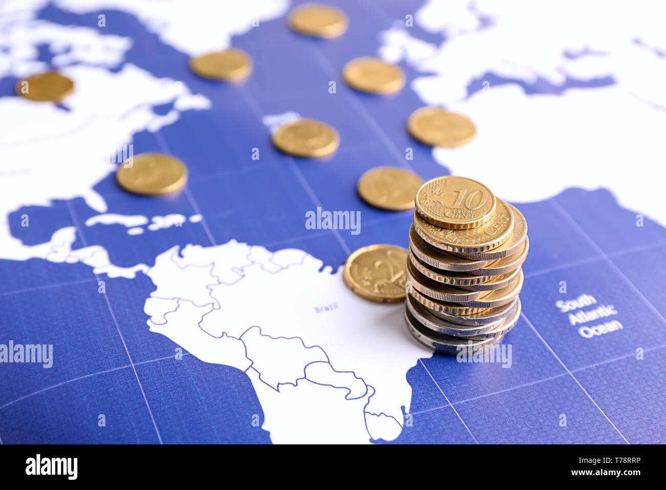 Coins on world map. Travel concept Stock Photo - Alamy