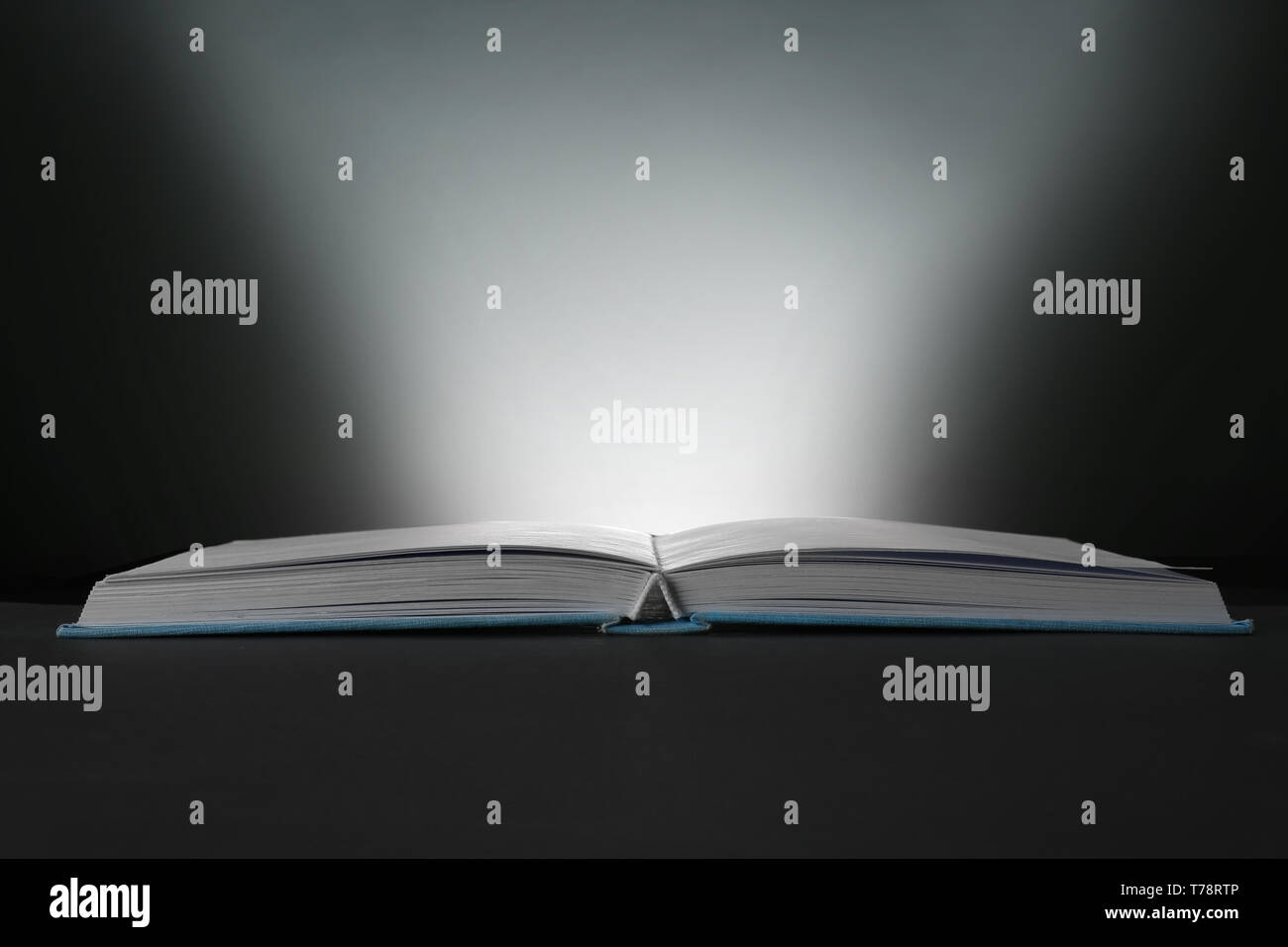 Open book with glowing on dark background Stock Photo - Alamy