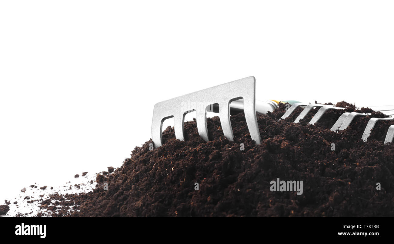 Gardening rakes with soil on white background Stock Photo - Alamy