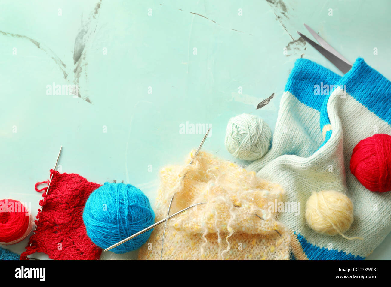 Composition with knitting yarn and unfinished clothes on table, top ...