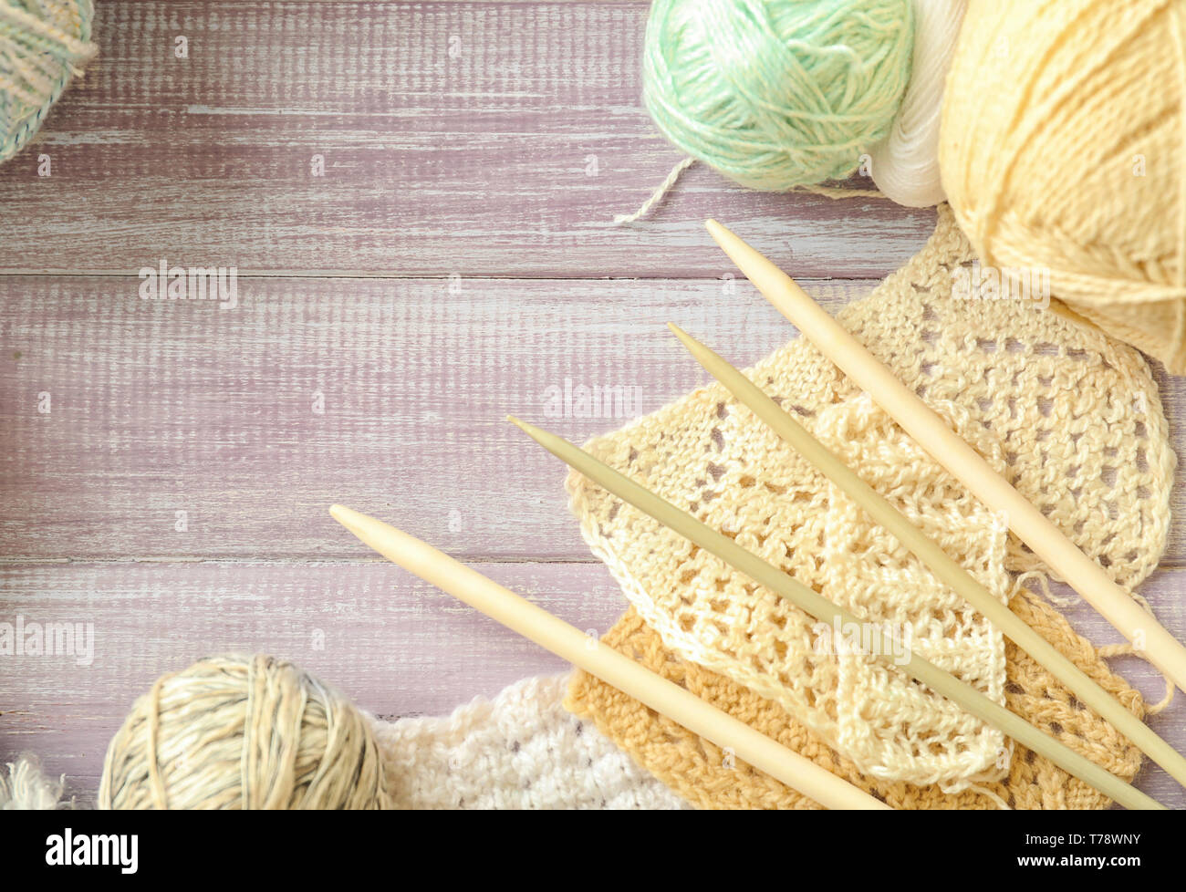 Unfinished knitting clothes with needles on wooden table Stock Photo ...
