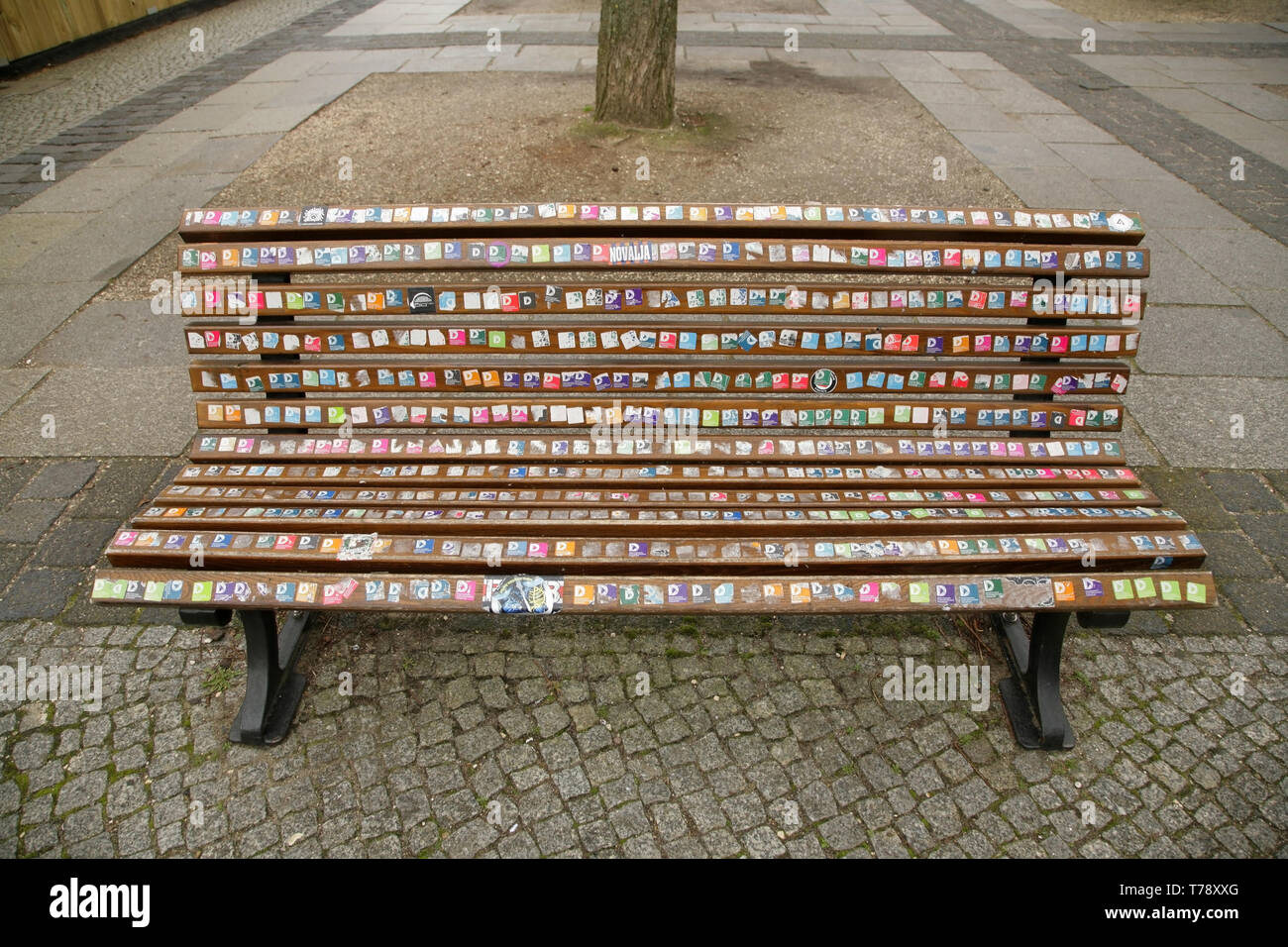 Wooden bench covered with lots of multi-coloured stickers for the ...