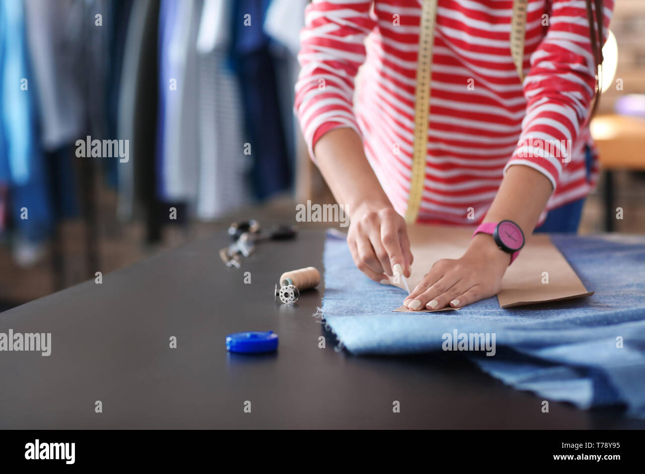 Young female tailor working with sewing pattern in atelier Stock Photo ...