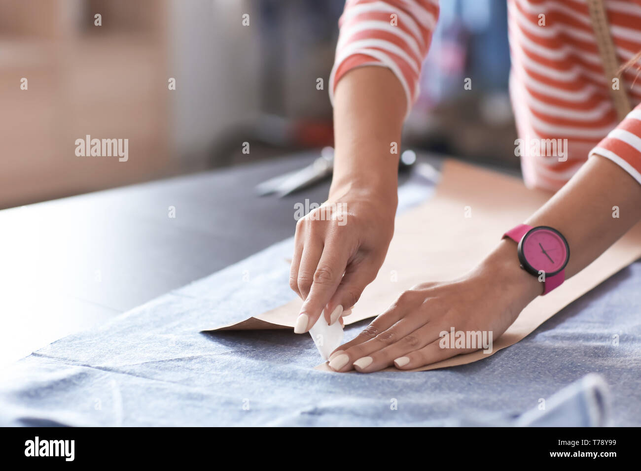 Young female tailor working with sewing pattern in atelier Stock Photo ...