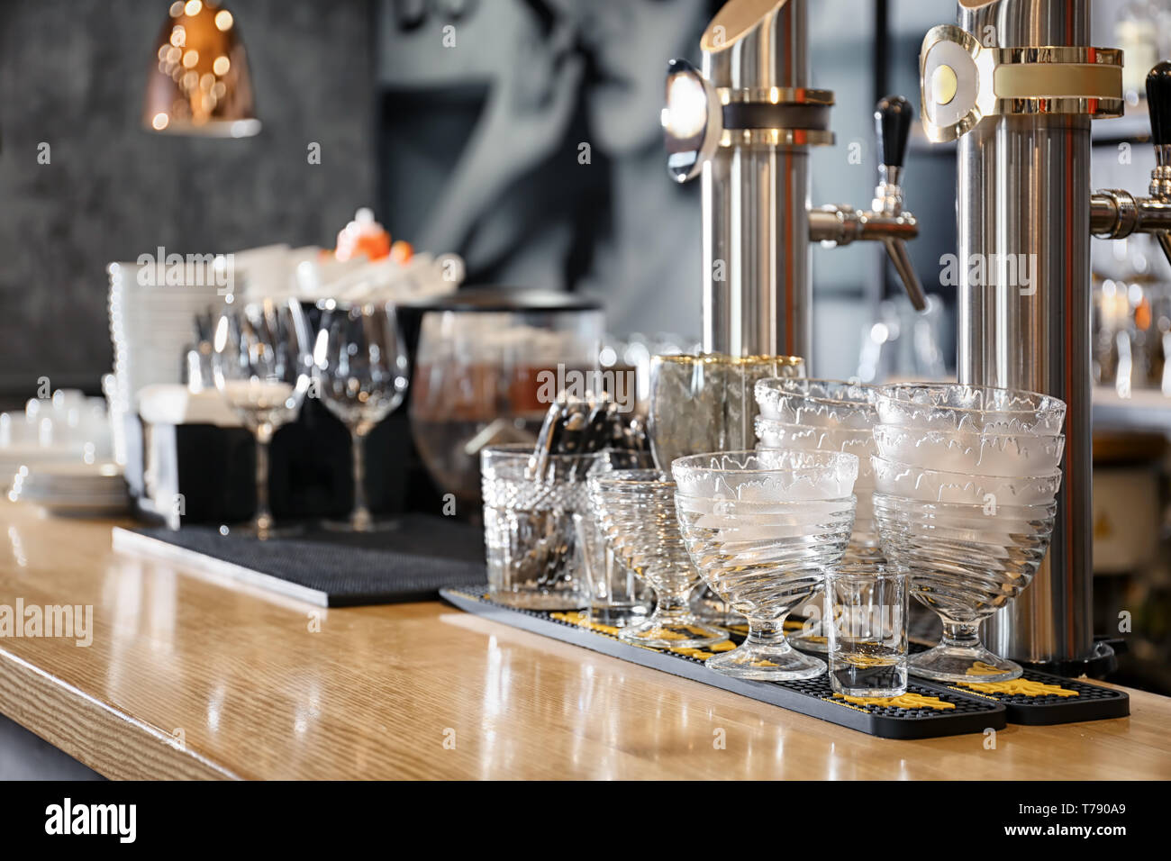 Draft beer taps with glassware on counter in modern bar Stock Photo - Alamy