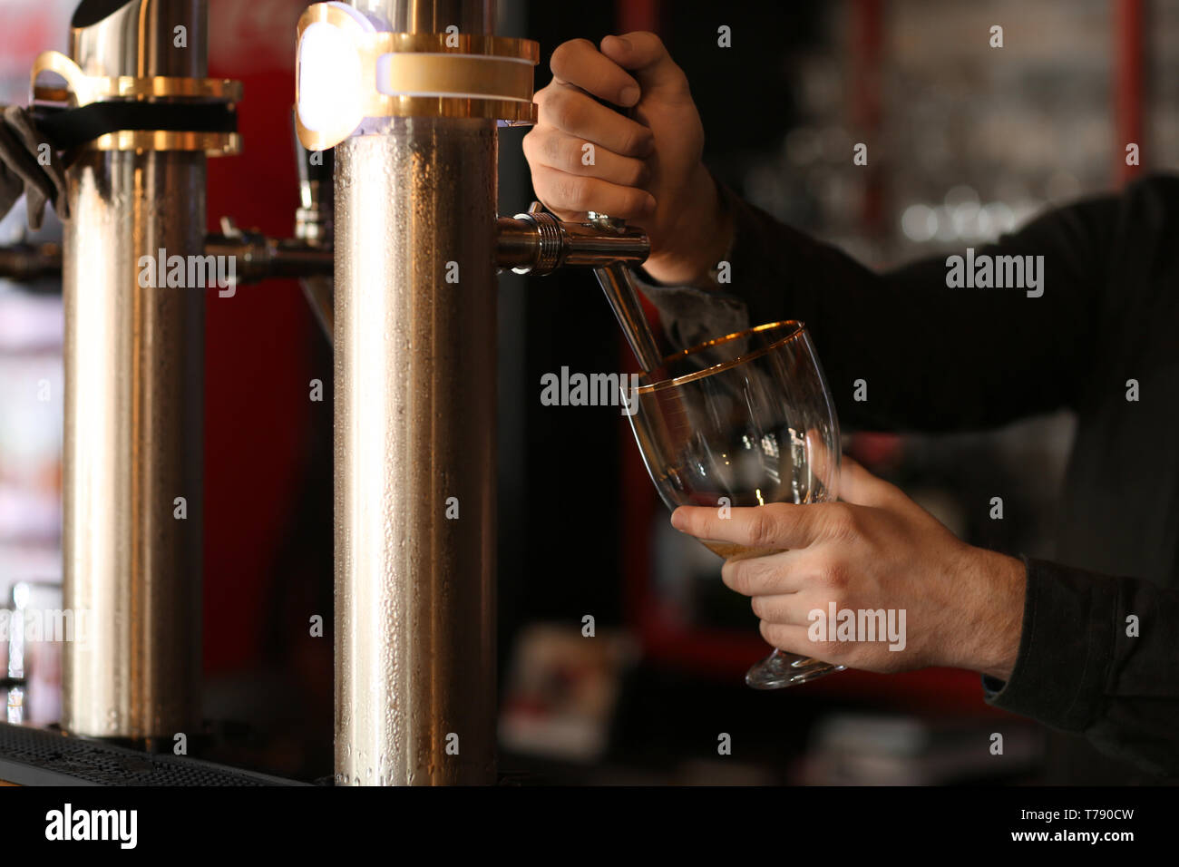 Bartender pouring beer into glass in bar Stock Photo - Alamy