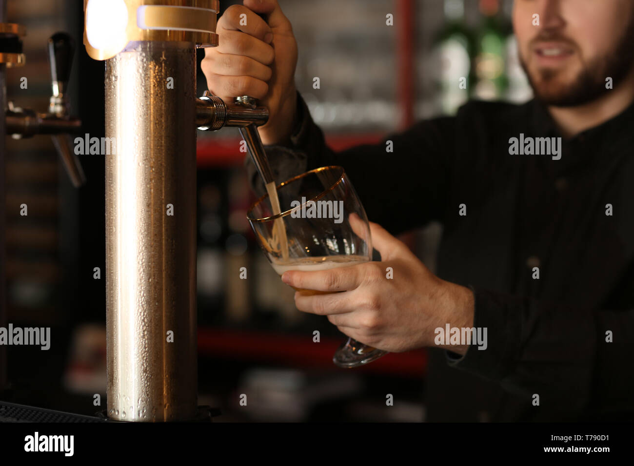 Bartender pouring beer into glass in bar Stock Photo - Alamy