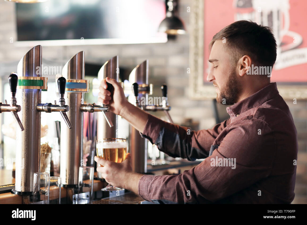Bartender pouring beer into glass in bar Stock Photo - Alamy